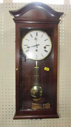 A modern wooden cased glazed panel door wall clock, with Roman numerals ...