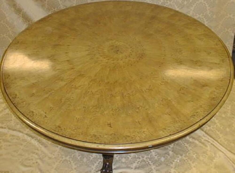 A fine pollard oak veneered circular dining table on trefoil base