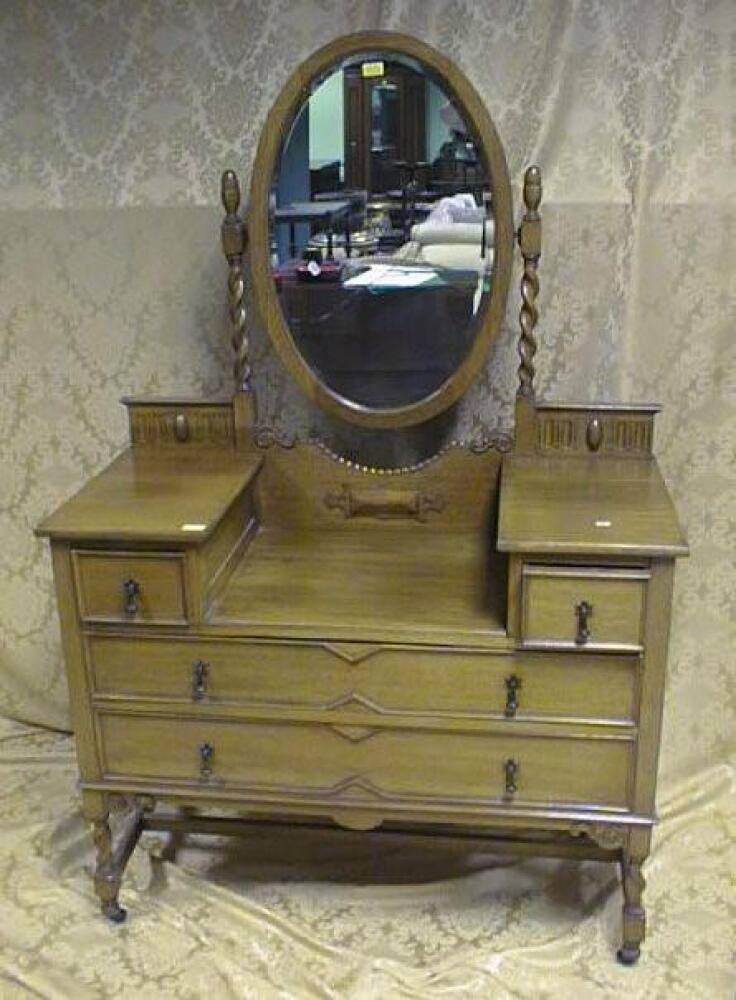 A barleytwist light oak dressing table with oval mirror and drop handles
