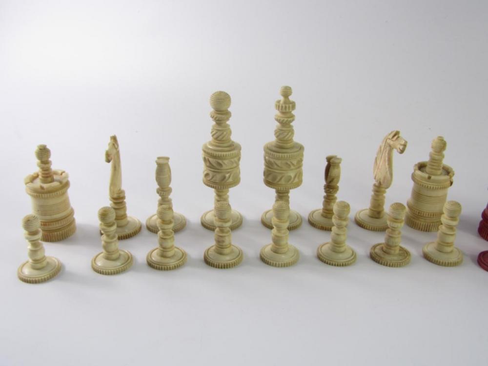 A Victorian carved and red stained bone chess set
