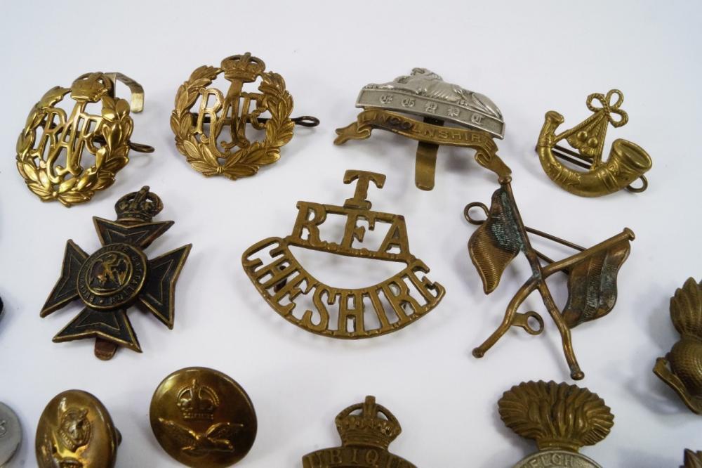 A group of Army and RAF cap badges and buttons