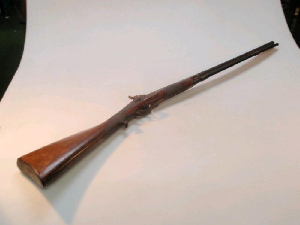 An antique black powder side lock percussion rifle