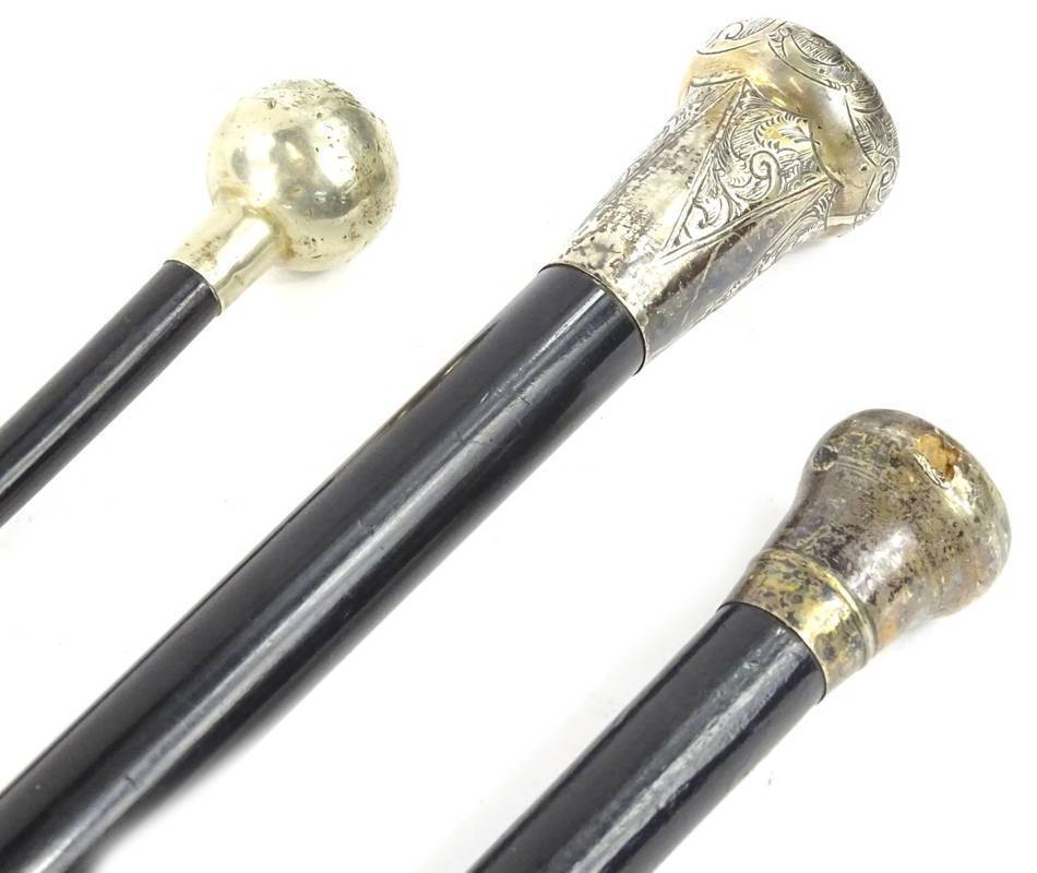 Two ebonised and silver mounted walking canes, and an ebonised swagger ...