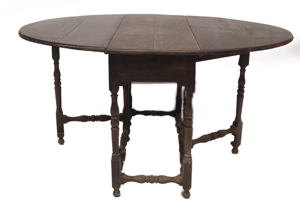 A 17thC walnut gateleg table, with oval drop leaf top, single frieze ...