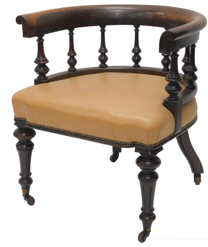 A Victorian walnut tub shaped library chair, with spindle turned ...