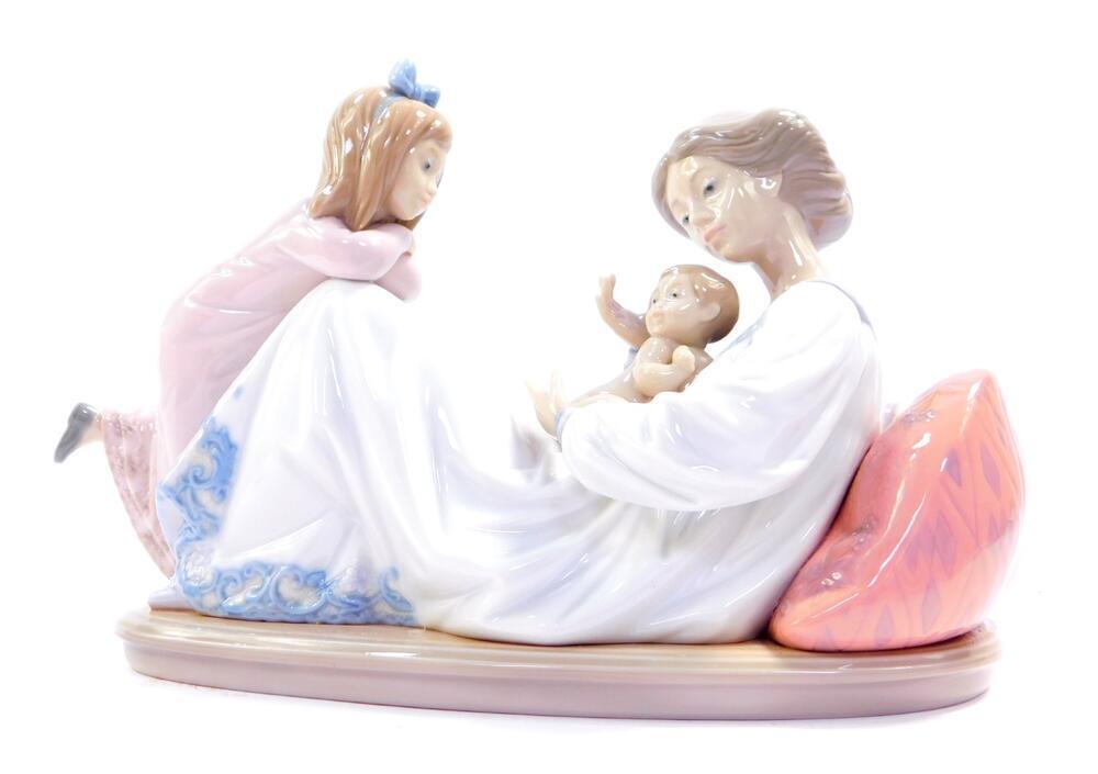 A Lladro porcelain figure group modelled as a lady in recumbent pose ...