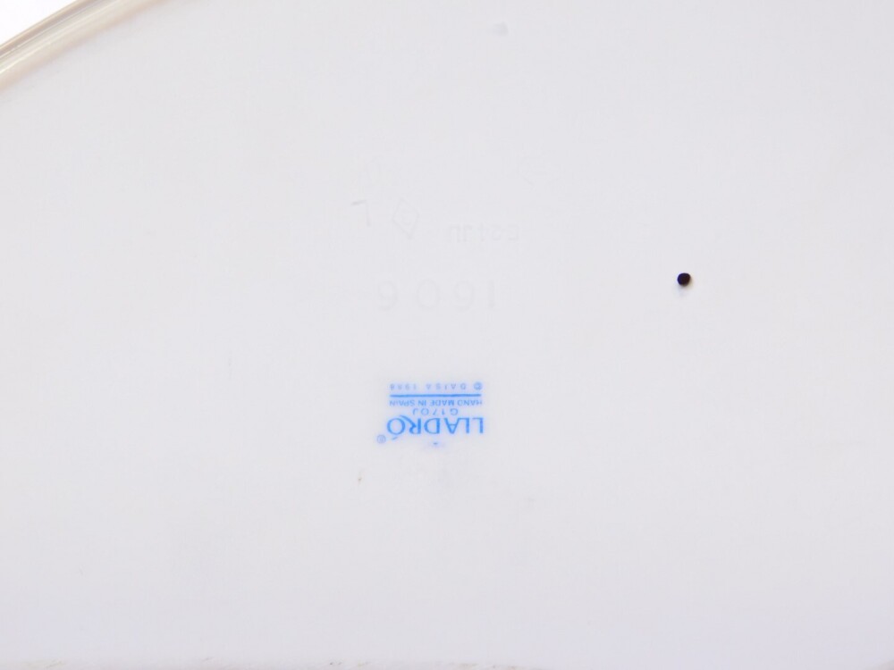 A Lladro porcelain figure group modelled as a lady in recumbent pose ...