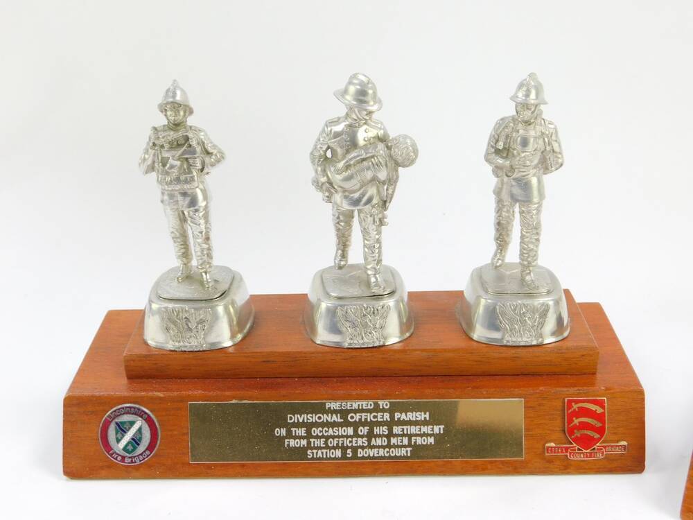 Five Charles C Stadden pewter figures of fireman, raised on two stepped ...