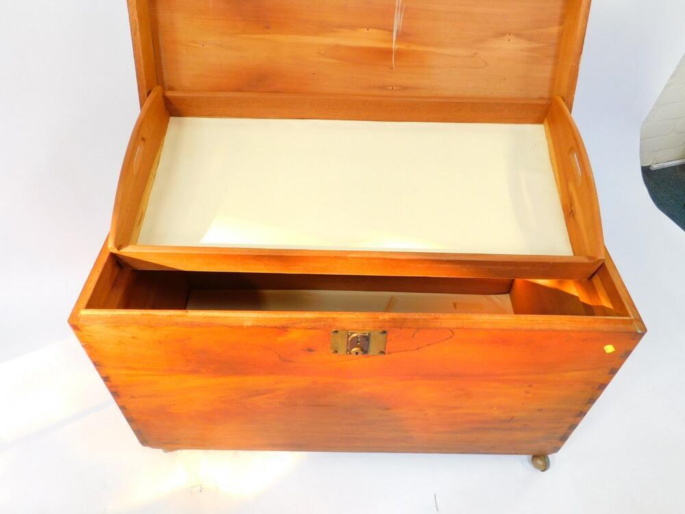 A teak chest, with cast iron handles and lock plate, opening to reveal ...