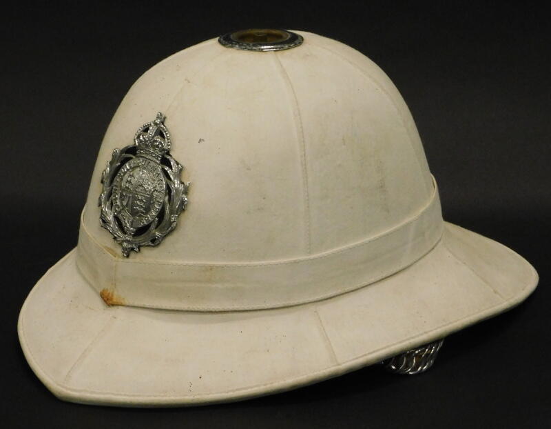 A WWI British colonial service pith helmet, with chrome plated badge ...