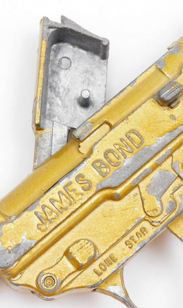 A James Bond Lonestar automatic cap gun, in gold with black handle.