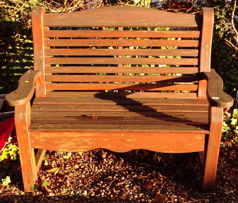 A stained wooden slatted garden bench.