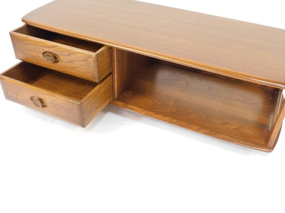An Ercol dark elm Minerva 844 two drawer coffee table, raised on ...