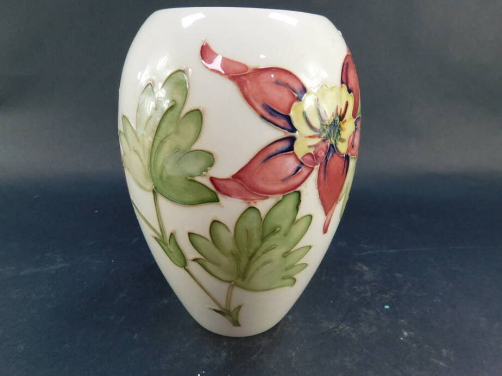A Moorcroft pottery vase decorated in the Columbine pattern, against a ...