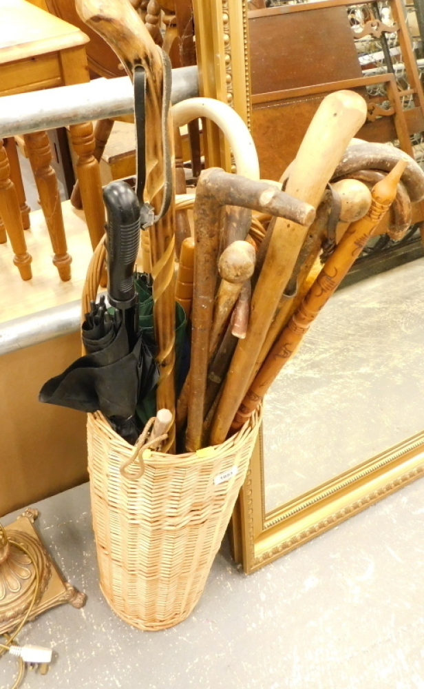Various walking sticks in a wicker stick stand.