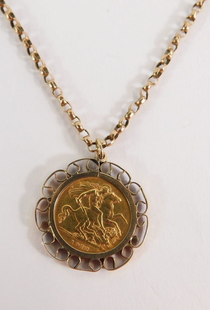 A George V half gold sovereign pendant and chain, the half gold ...