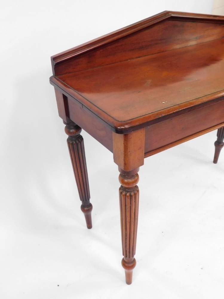 A Victorian mahogany hall table, with a triangular shaped back, above ...