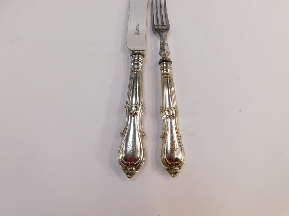 A cased set of twelve silver plated knives and forks, each with a ...