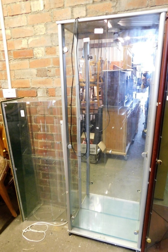 A glass two door shop display cabinet, with various shelves and ...