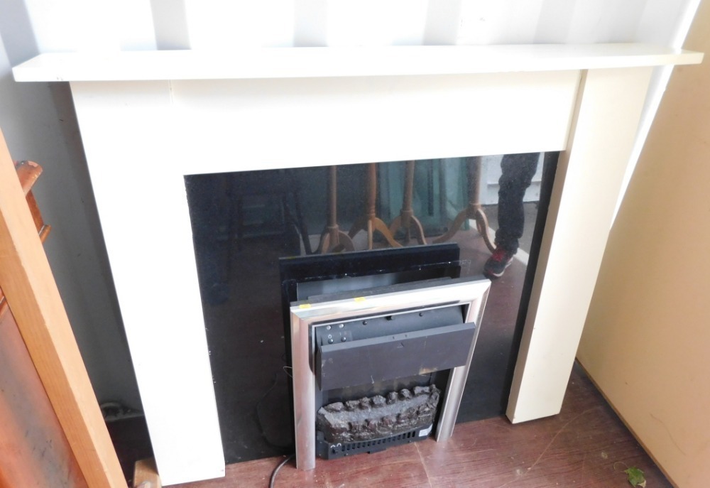 A modern white painted fire surround, with a coal effect electric insert.