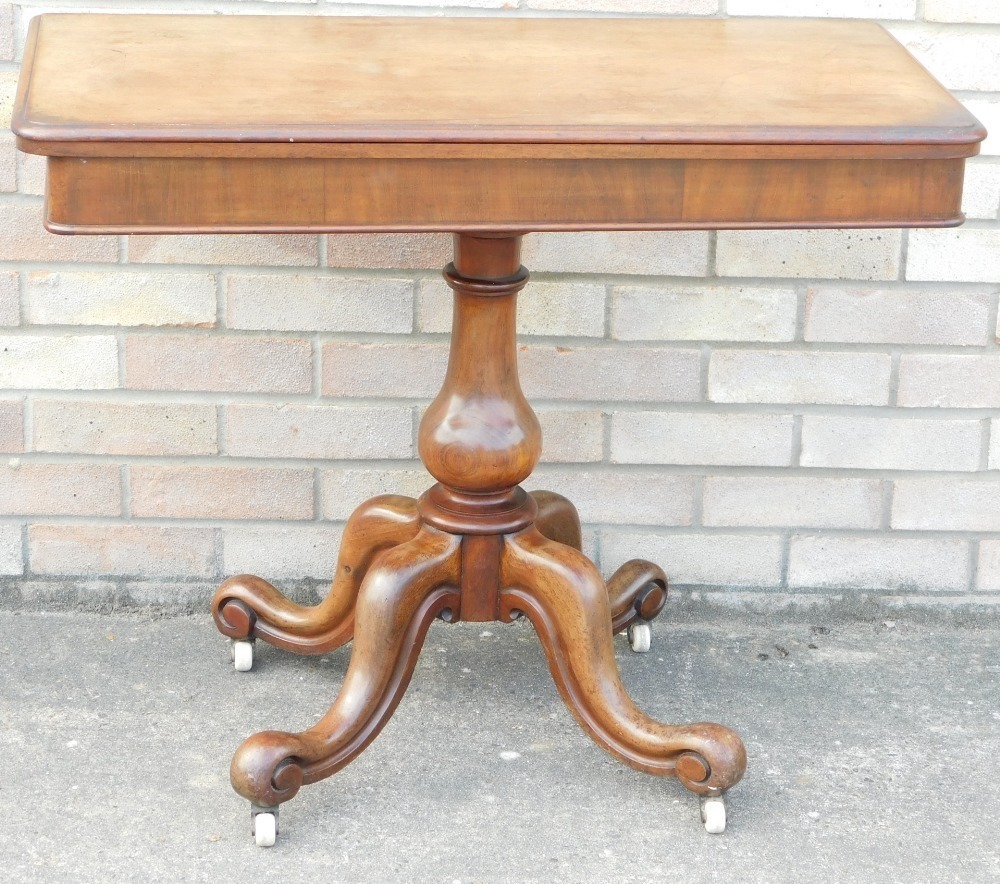 A Victorian mahogany fold over tea table, the rectangular top with ...