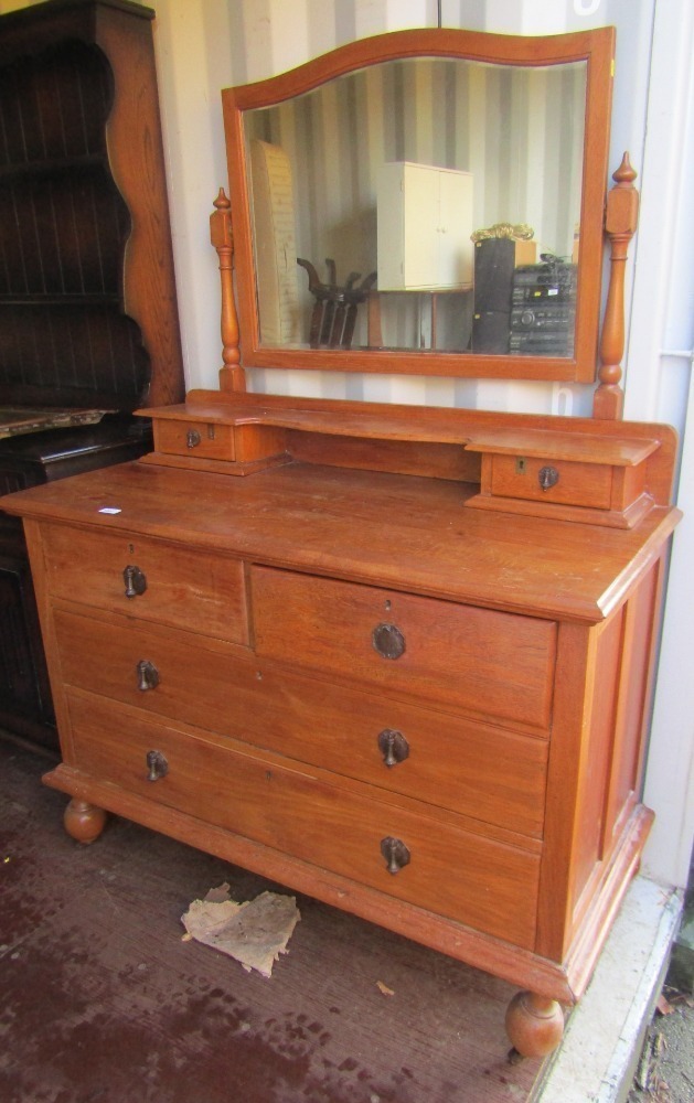 A light oak dressing table, with dressing table mirror, above a raised ...