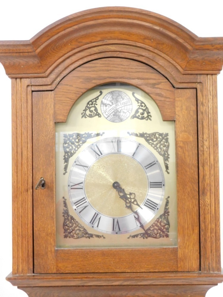 A 20thC oak cased longcase clock, with arched hood and brass dial with ...